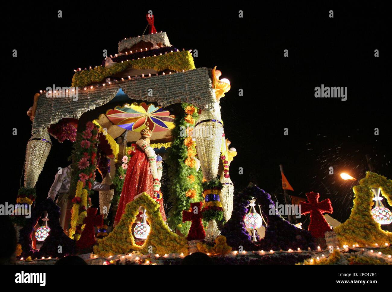 A statue of Infant Jesus, center, is placed on a decorated chariot ...