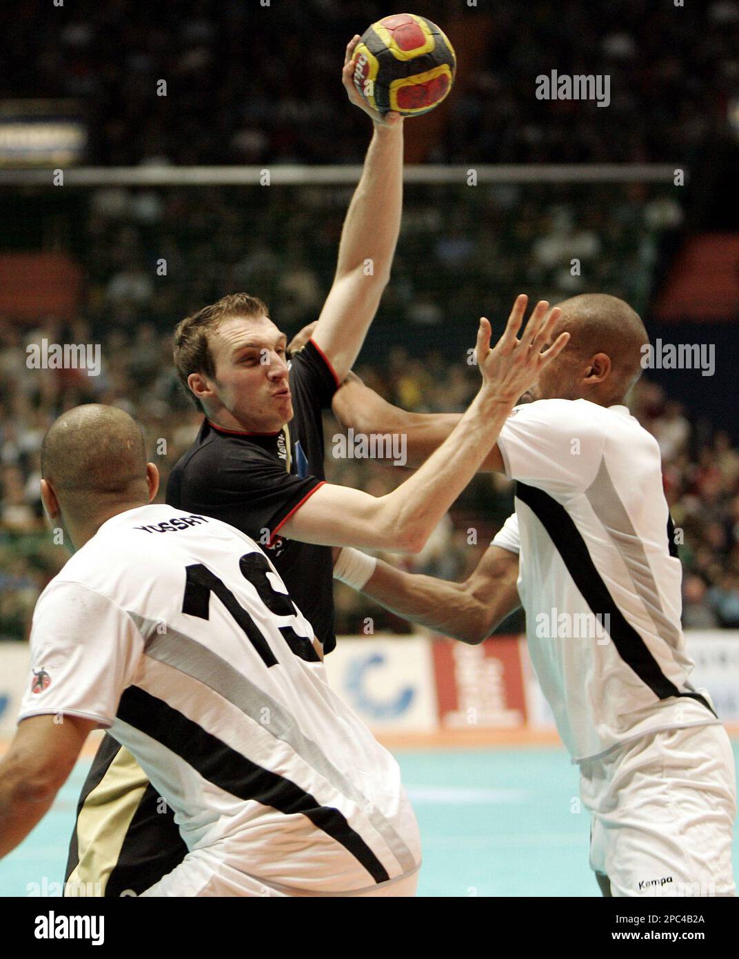 German handball player Holger Glandorf, center, and Egypt handball ...