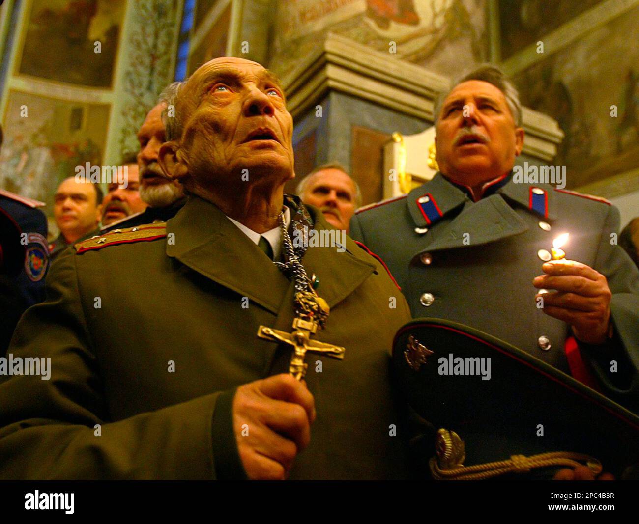Mourners pray at a reburial ceremony of the remains of White Army ...