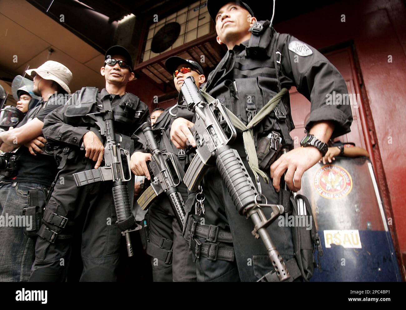 Police officers take shelter from the rain as protesters are stopped by ...