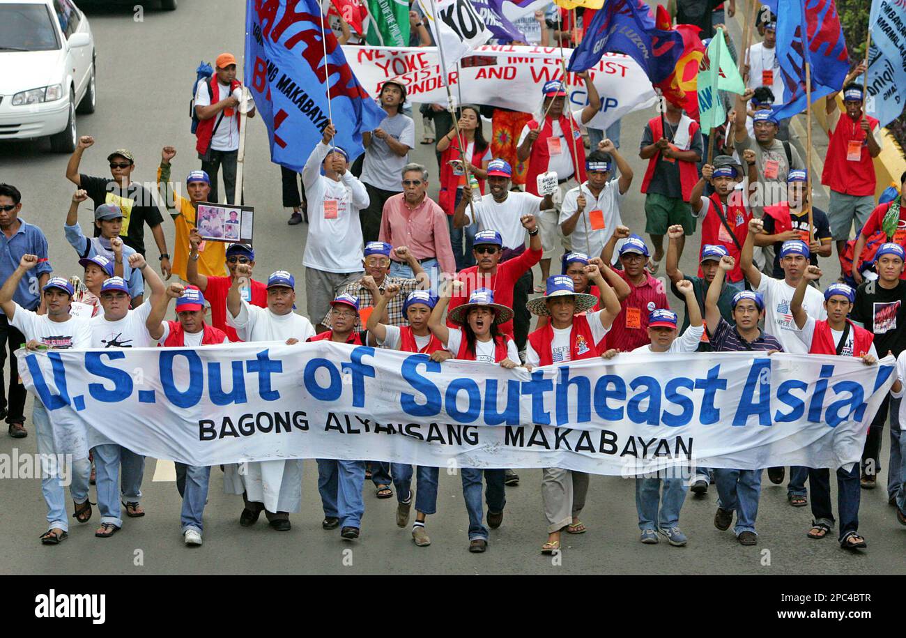 Filipino protesters raise their clenched fists as they march during a ...