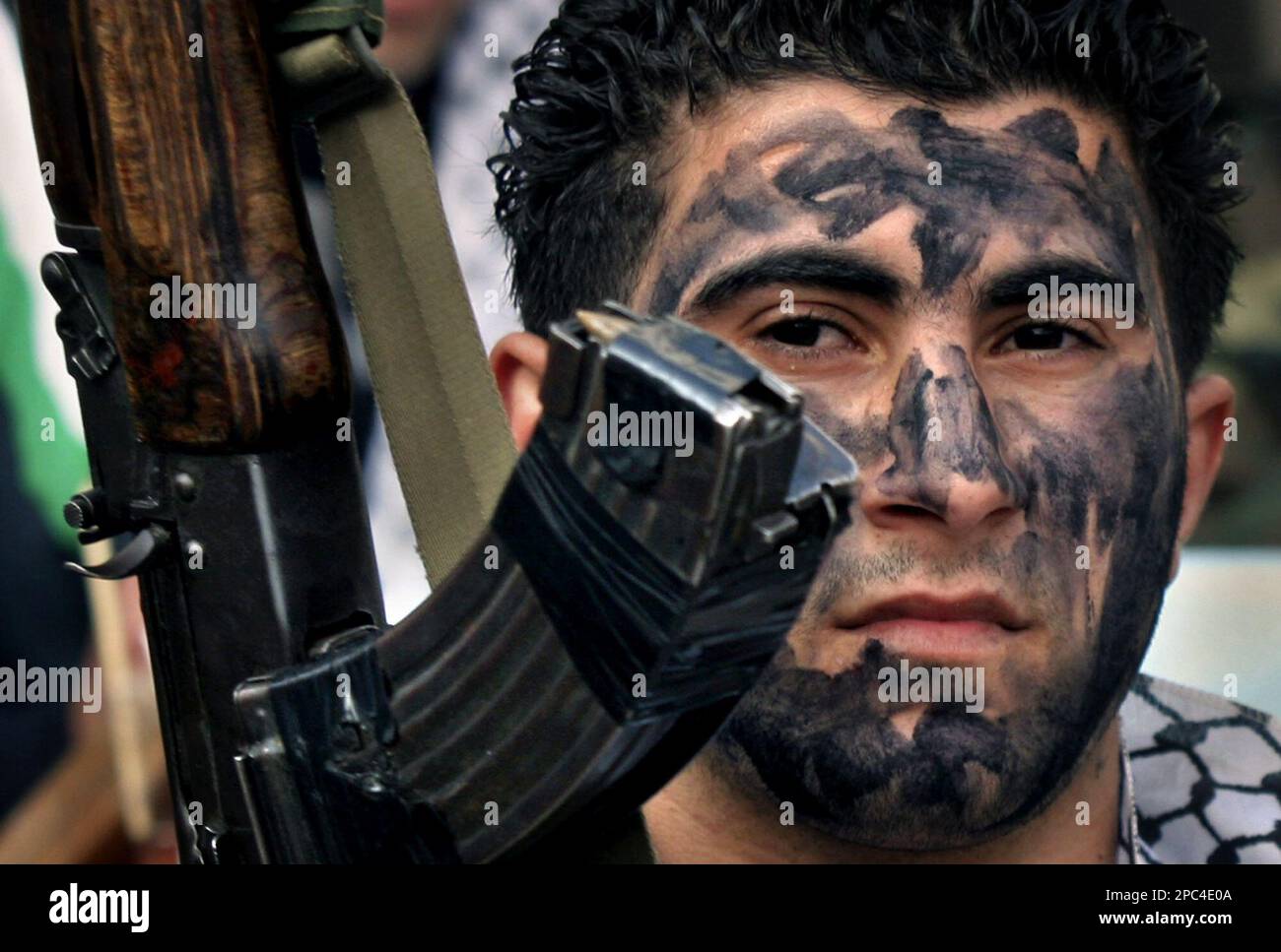 A Palestinian militant from Al-Aqsa Martyrs Brigades holds his weapon ...