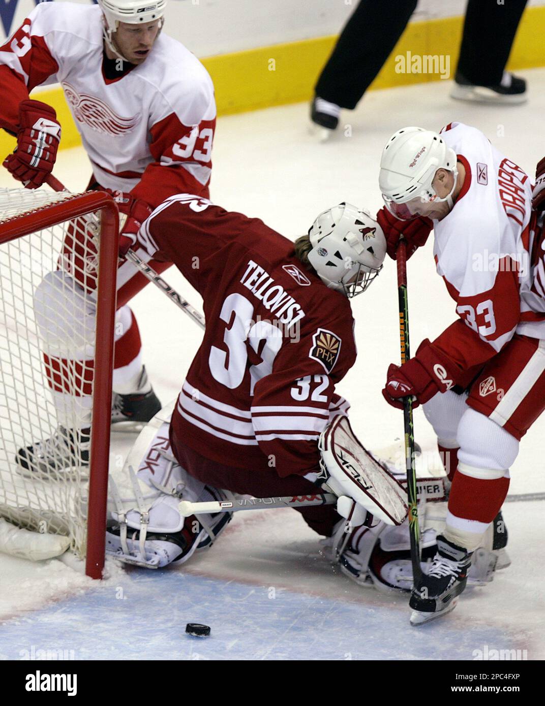 Detroit Red Wings center Kris Draper, right, kicks the puck in the net ...