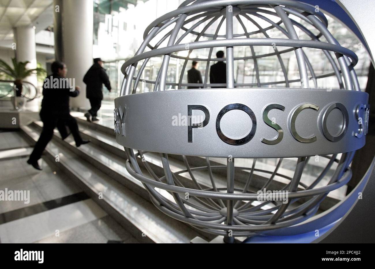 Visitors walk past a sculpture displaying the Posco logo at the company ...