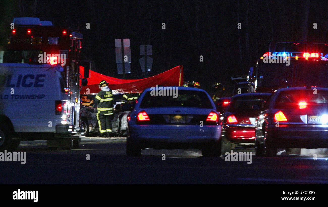 People examine a car involved in a multi-car crash that killed four ...