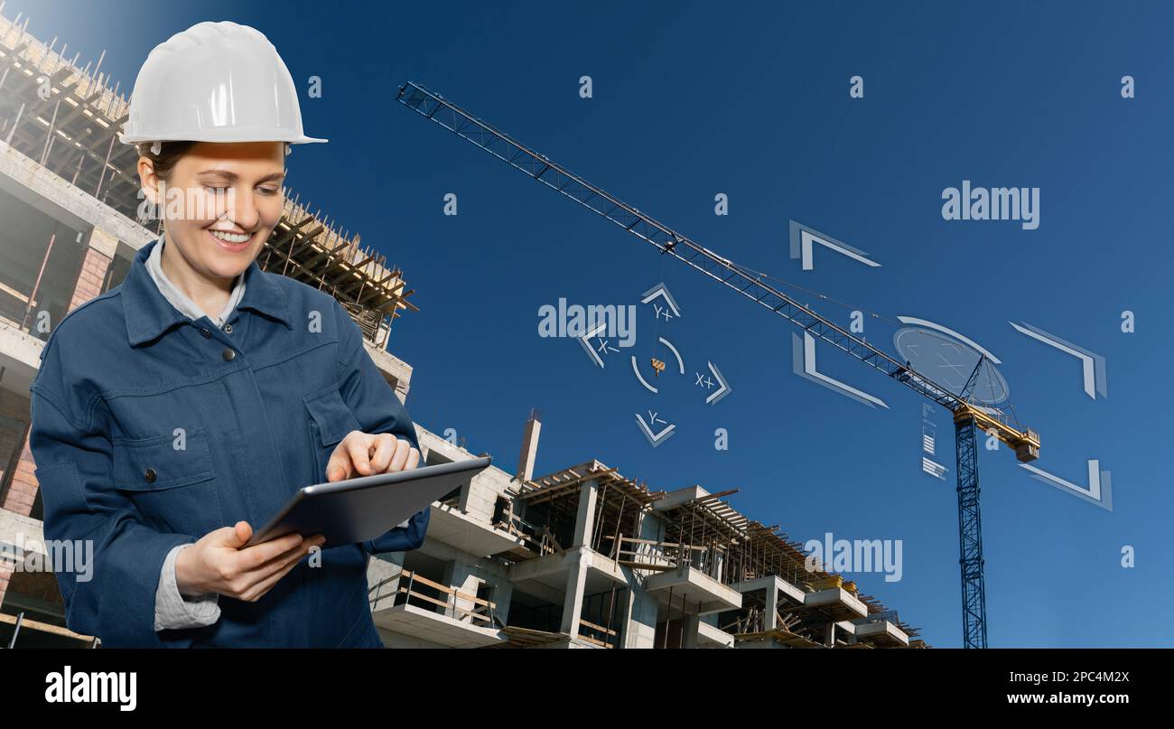 Woman with a digital tablet controls a remote-controlled unmanned crane ...
