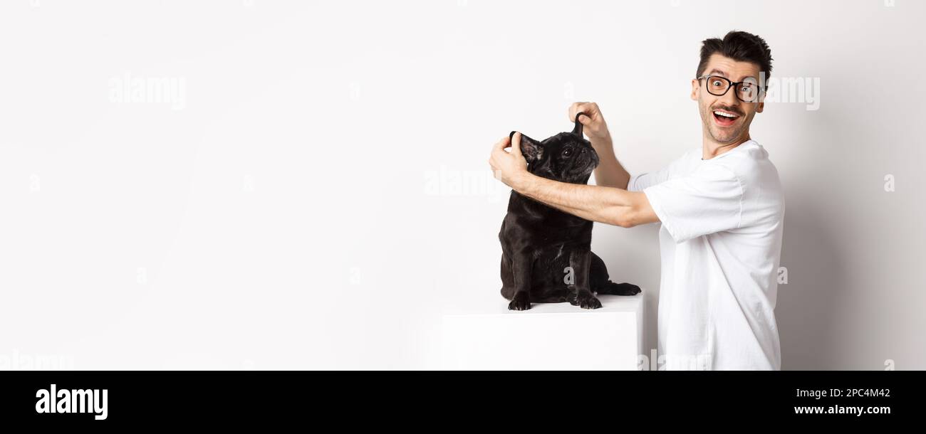 Happy young man looking at camera, showing cute dog ears and feeling ...