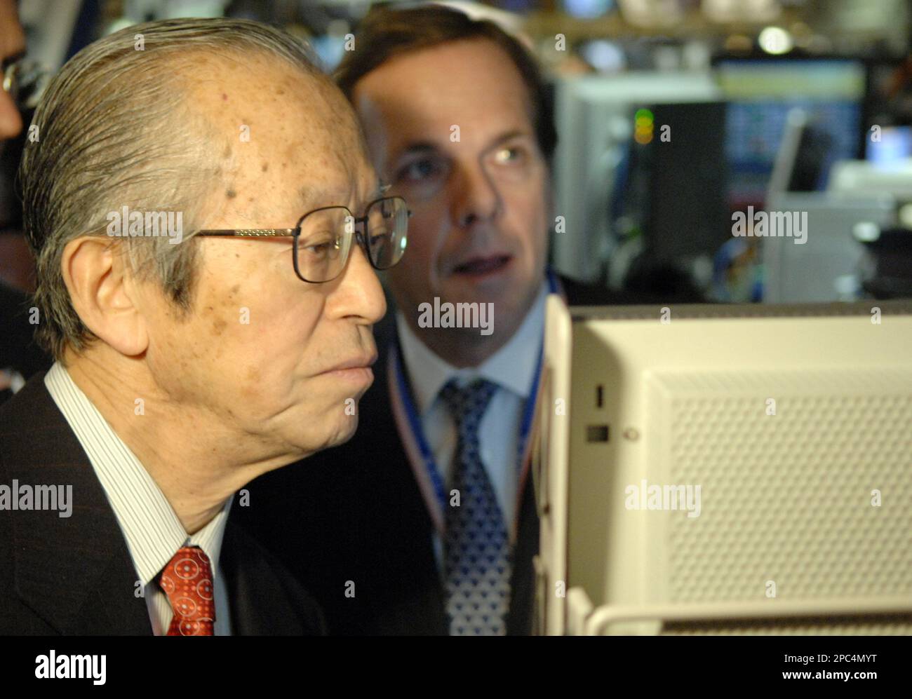 Japanese Finance Minister Koji Omi, left, is shown a trading post by ...