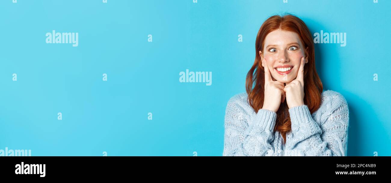 Close-up of funny redhead teen girl making faces, squinting and ...