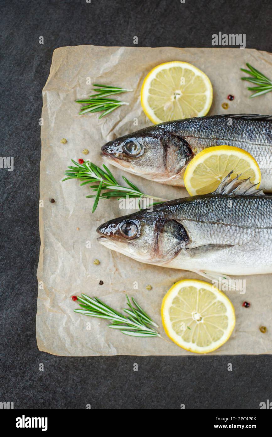 Fresh fish with spices and herbs on table in kitchen. Fresh sea bass ...