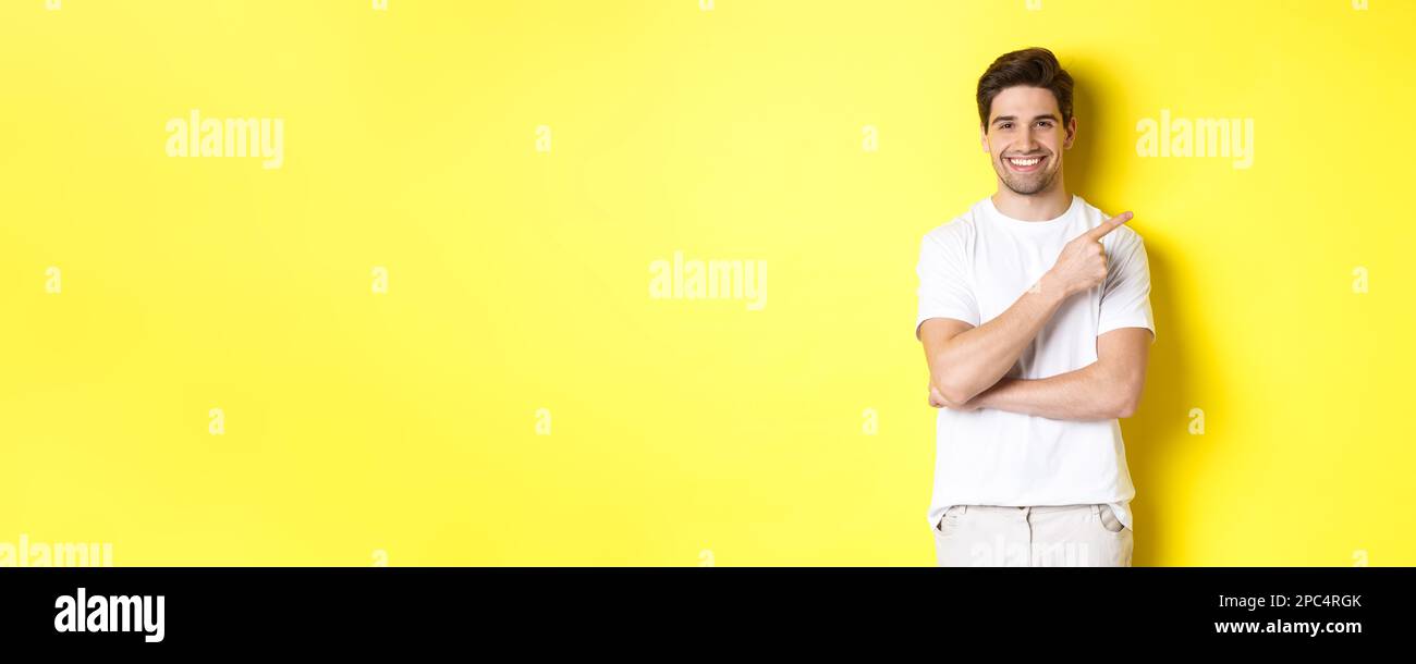 Image of attractive young man pointing finger right at copy space ...