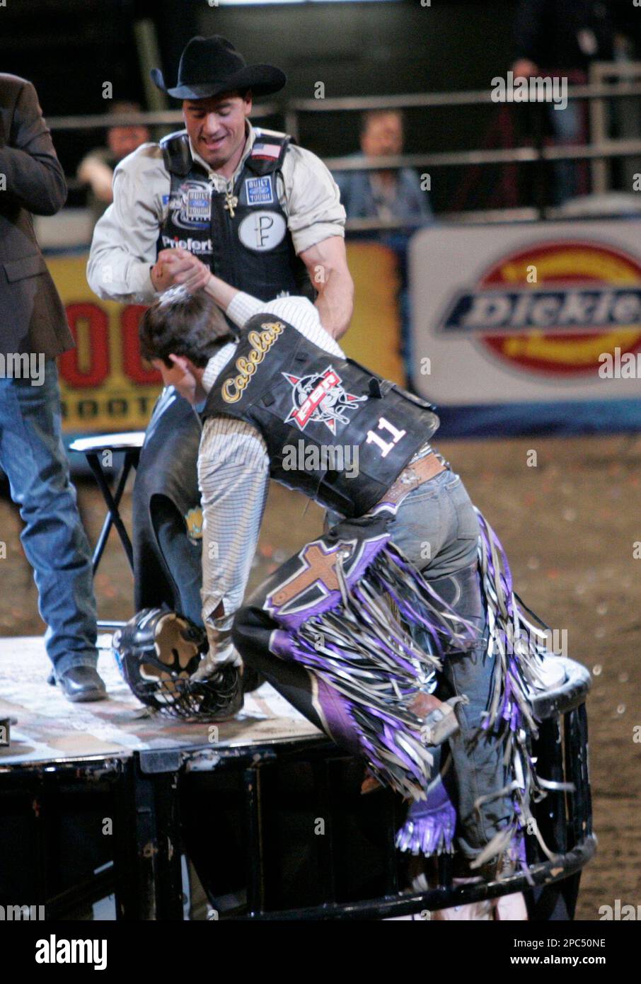 Bull rider Adriano Moraes, of Brazil, pulls J.B. Mauney on top of the ...