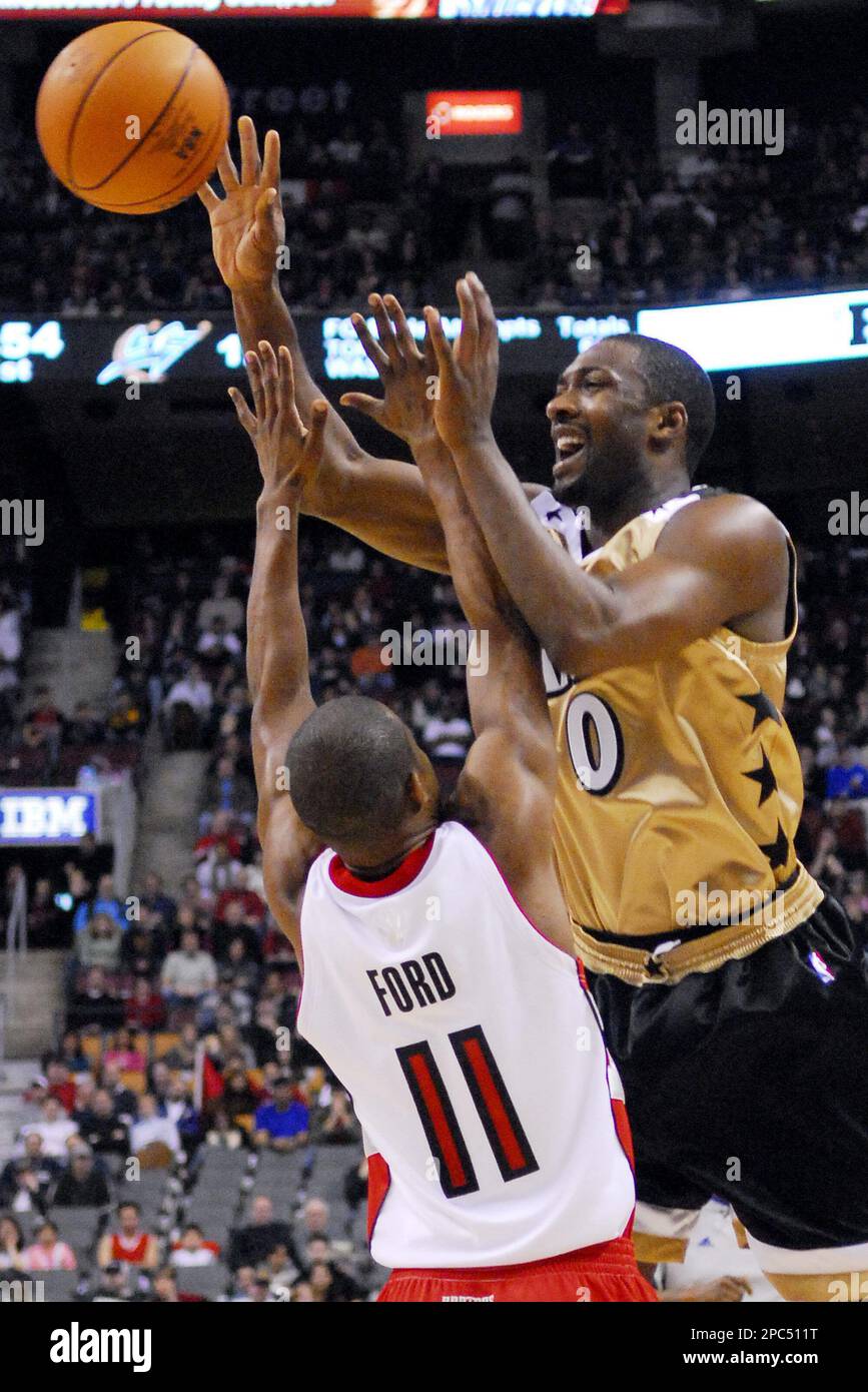 Washington Wizards' Gilbert Arenas, right, passes over Toronto Raptors ...