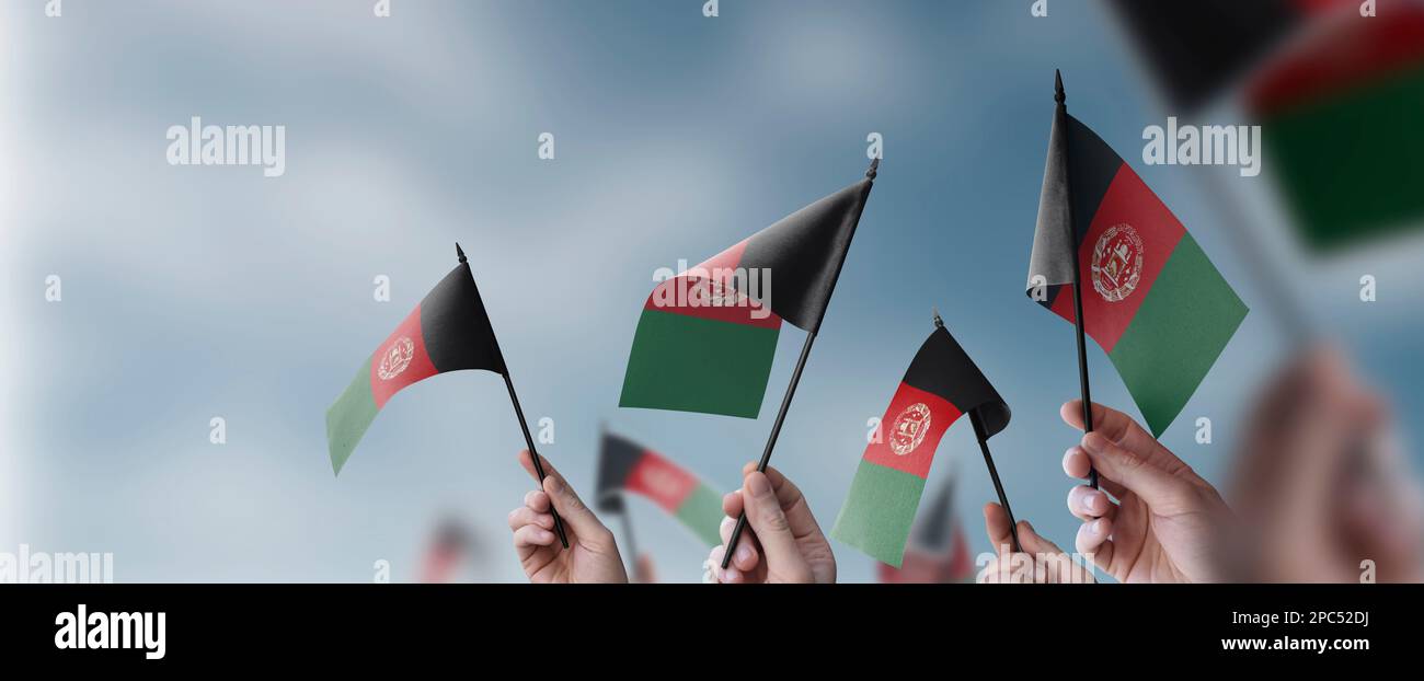 A group of people holding small flags of the Afghanistan in their hands ...