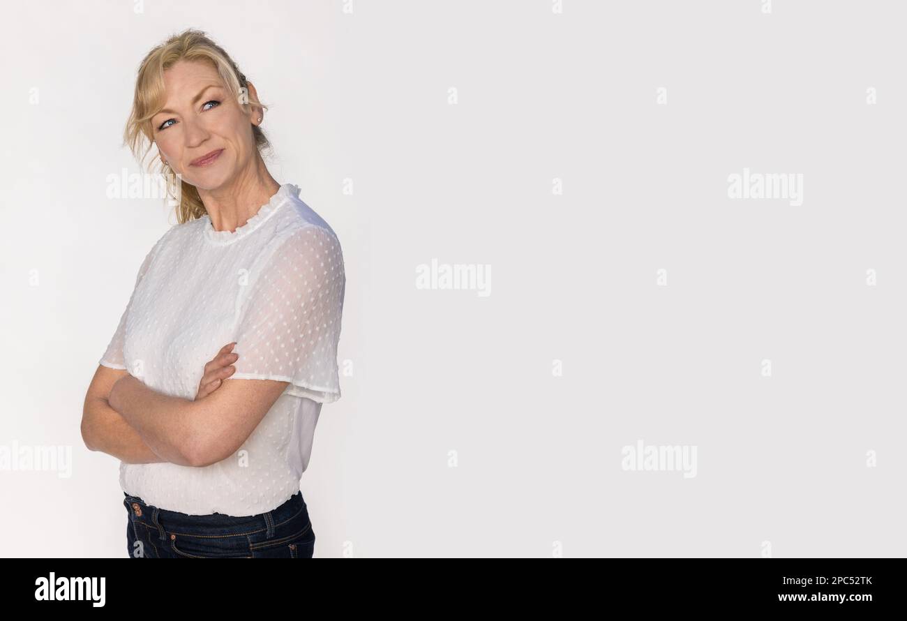 Attractive happy smiling female middle aged woman looking up in a studio portrait on white ...