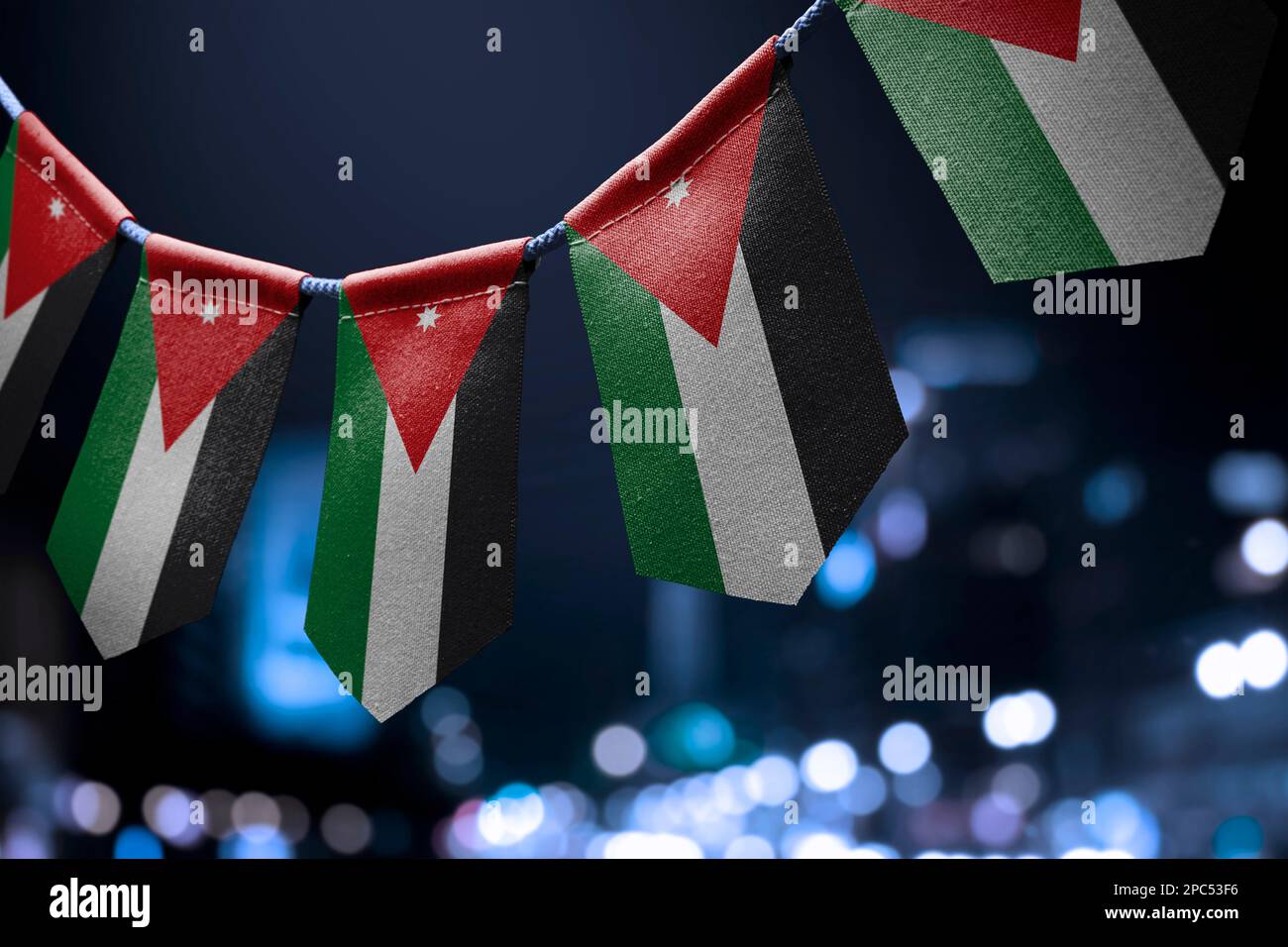 A garland of Jordan national flags on an abstract blurred background ...