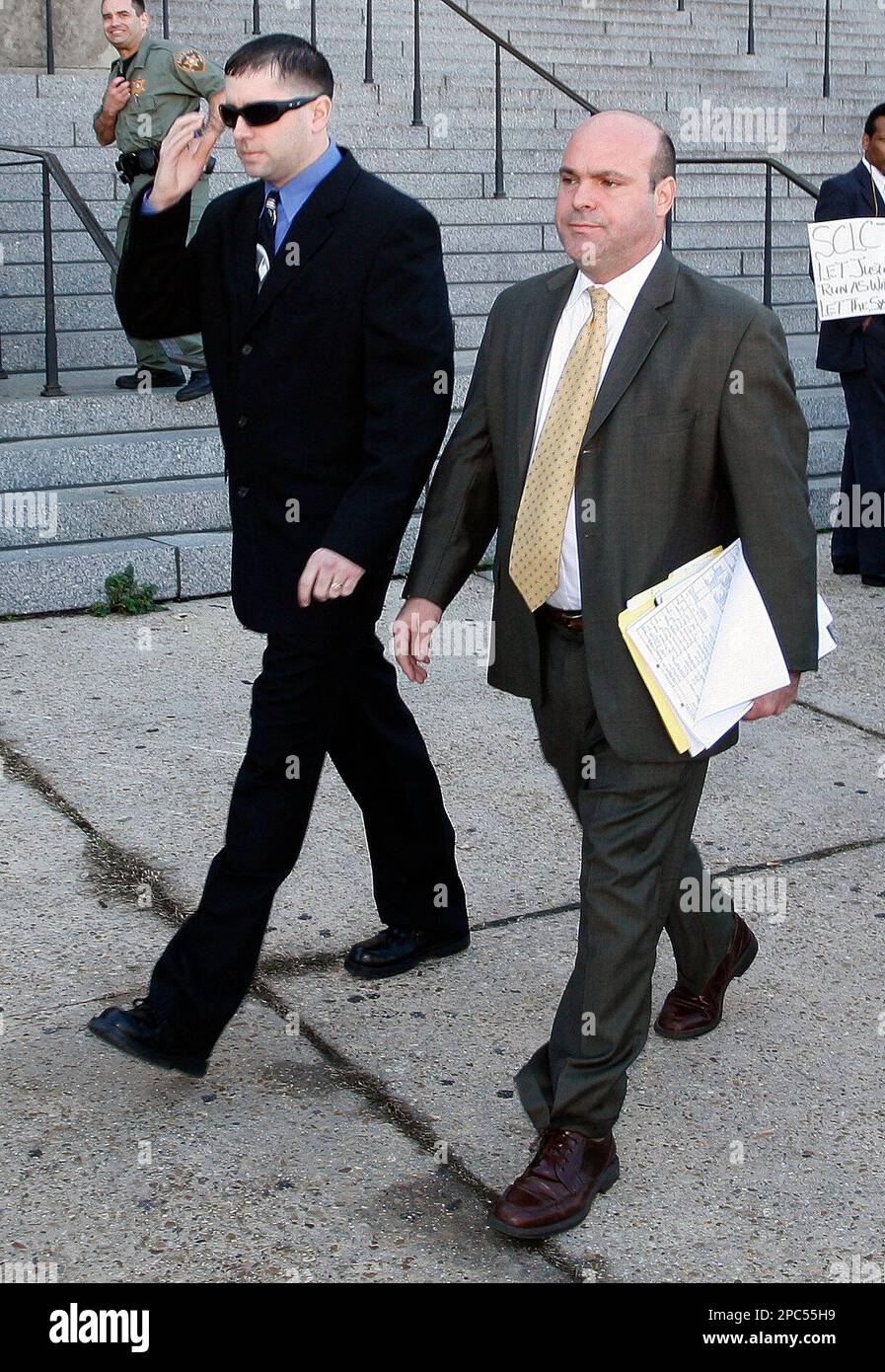 Suspended New Orleans police officer Michael Hunter, left, leaves the ...