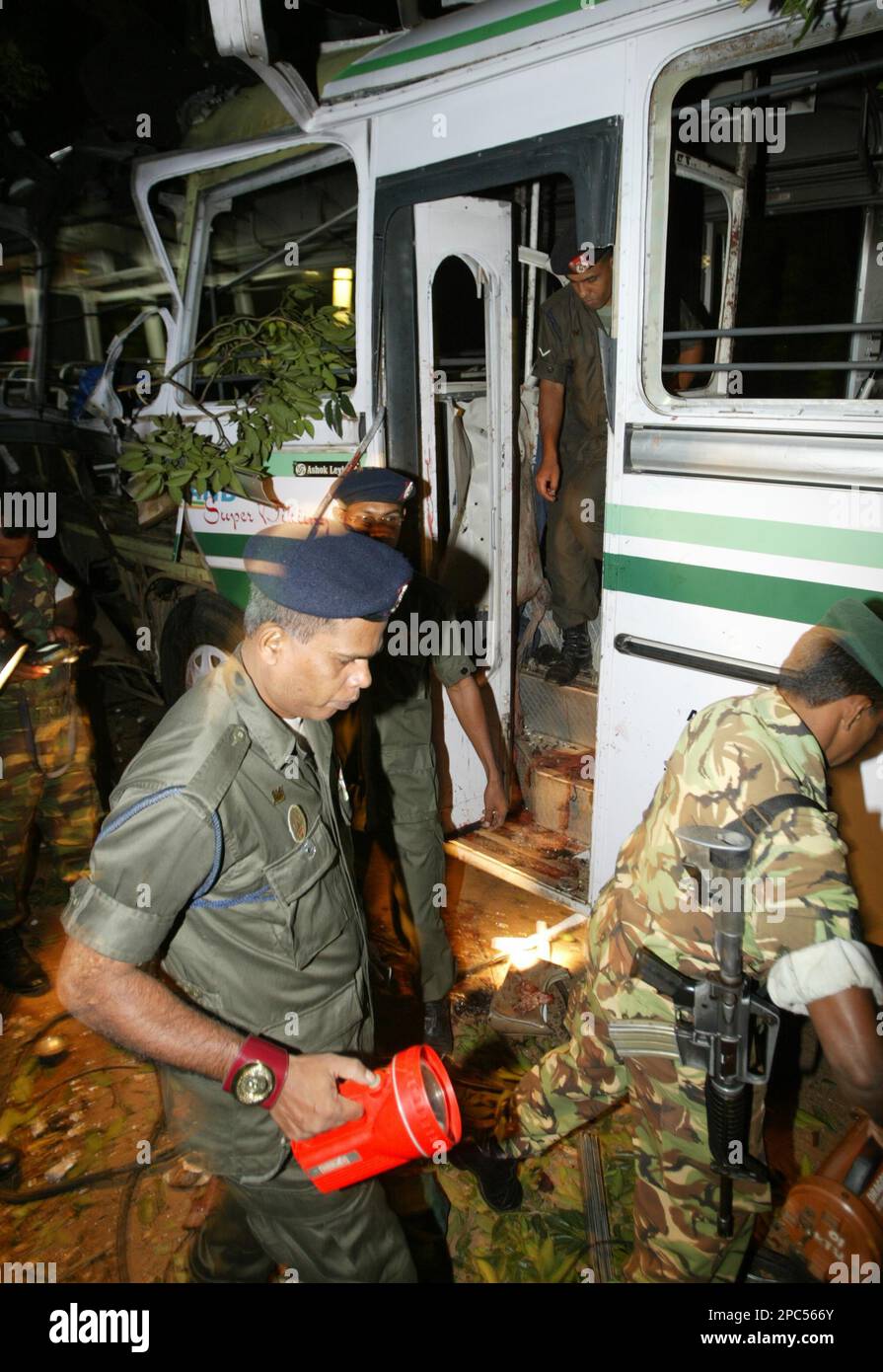 Sri Lankan soldiers inspect the wreckage of the bus at an explosion ...