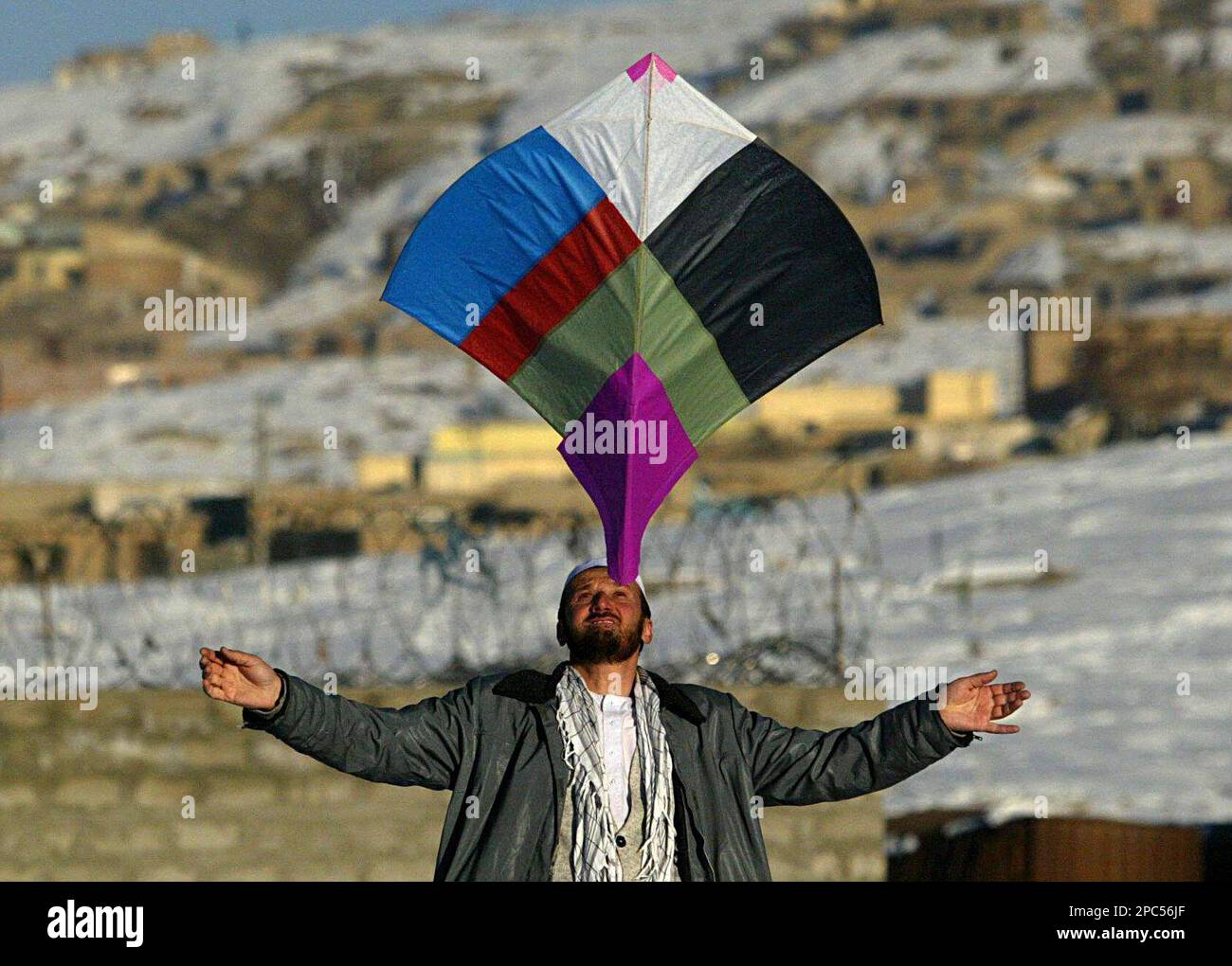 An Afghan man flies kite during a kite competition in Kabul ...