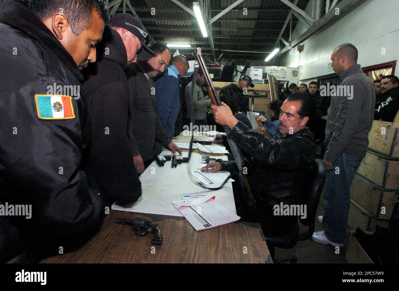 Tijuana city police line up to hand over their weapons in Tijuana ...