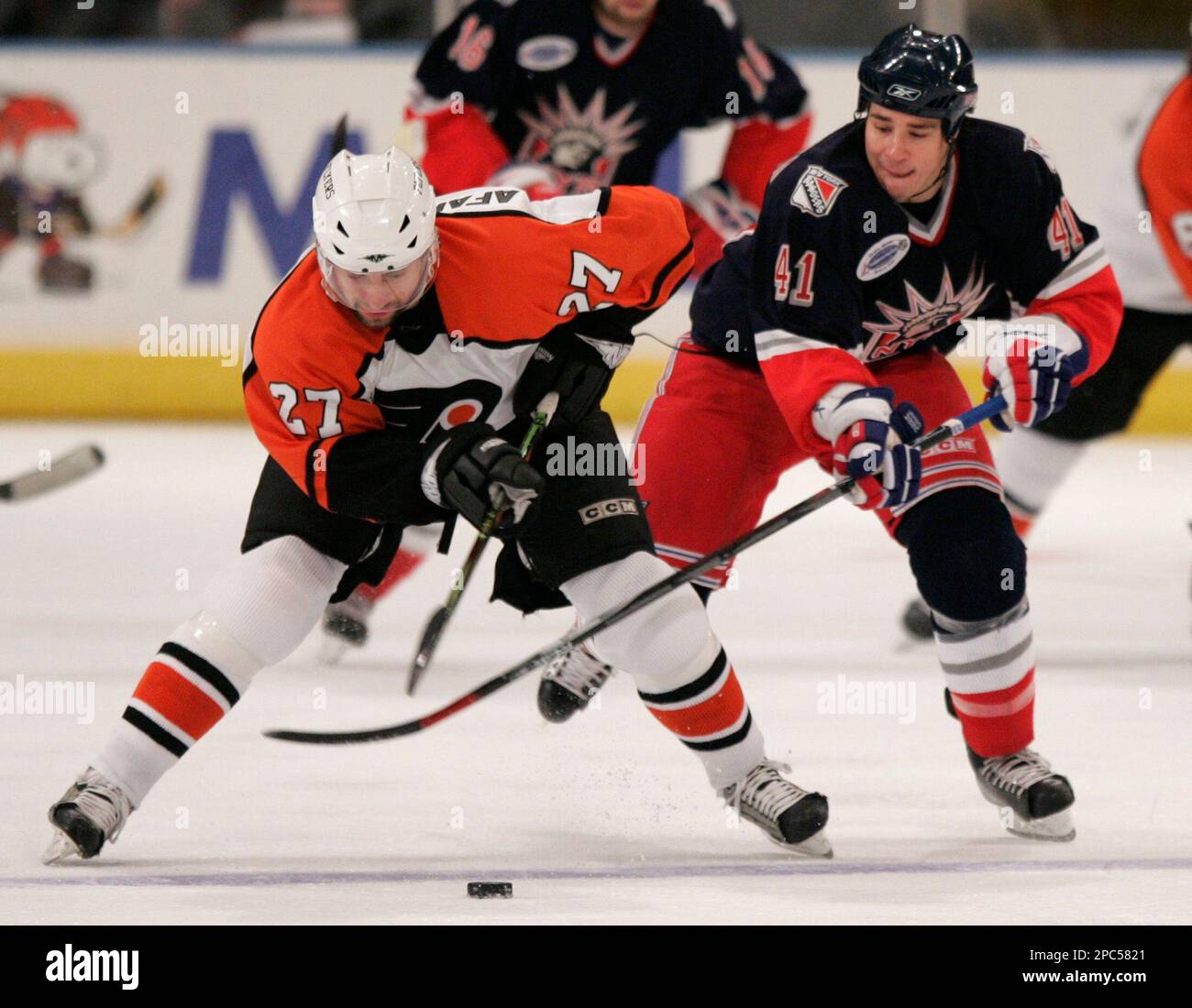 Philadelphia Flyers' Dmitry Afanasenkov, left, fends off an attempt by ...