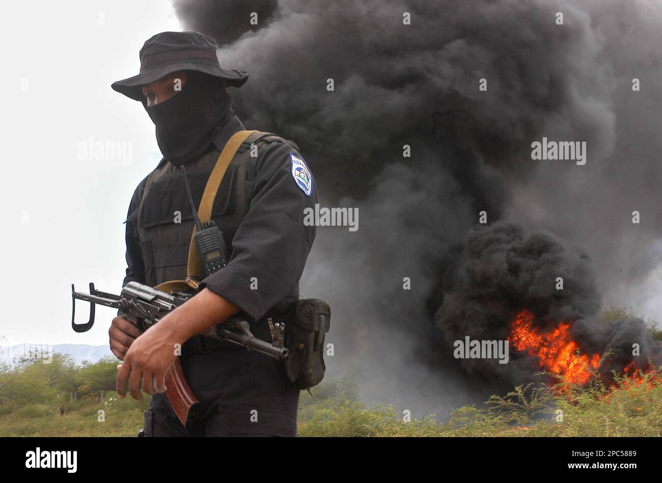 An anti-narcotic police officer stands next to packages of cocaine on ...