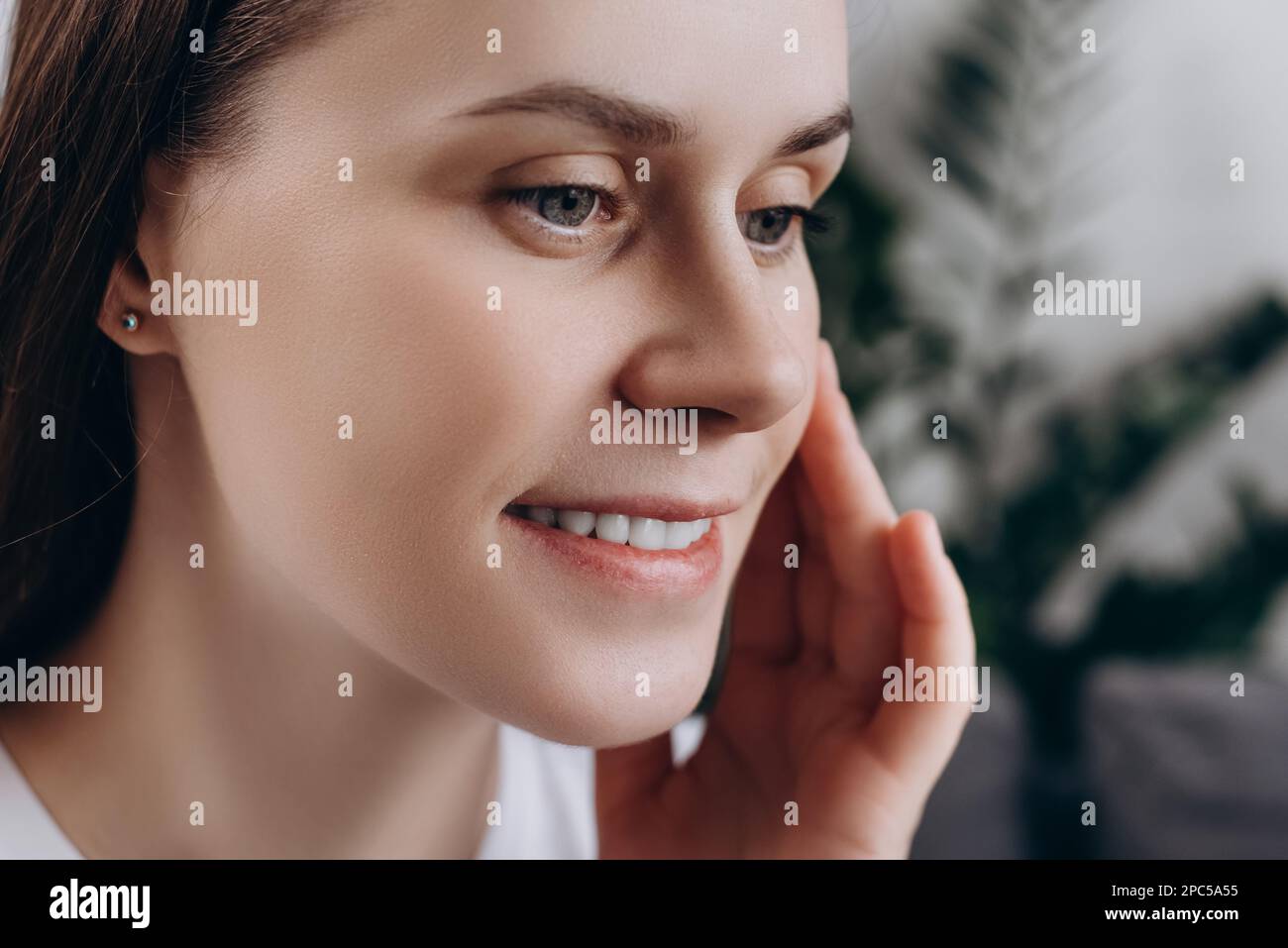 Close up portrait of happy beautiful girl holding cheek with laugh ...