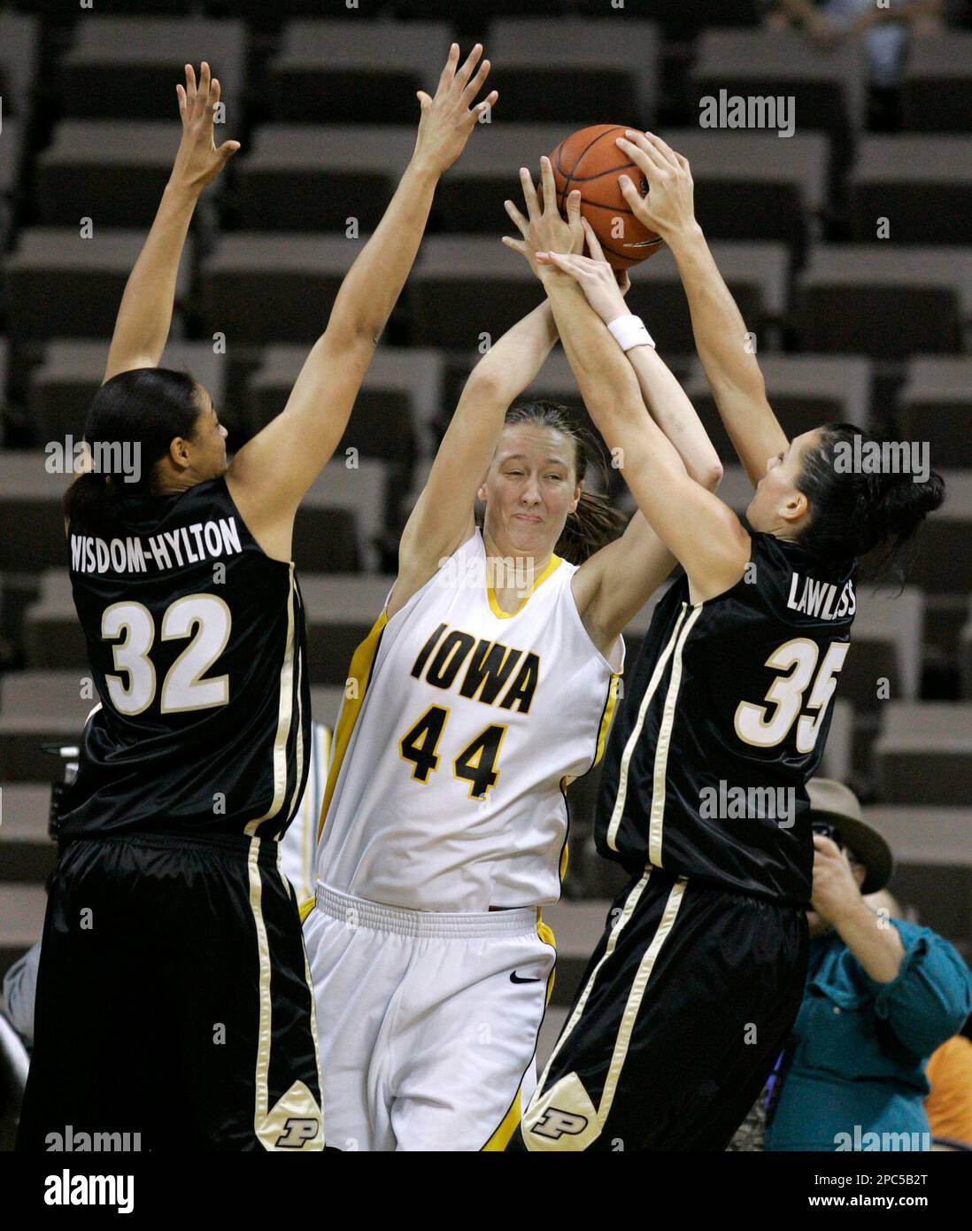 Iowa's Megan Skouby, center, looks to pass between Purdue's Lindsay ...