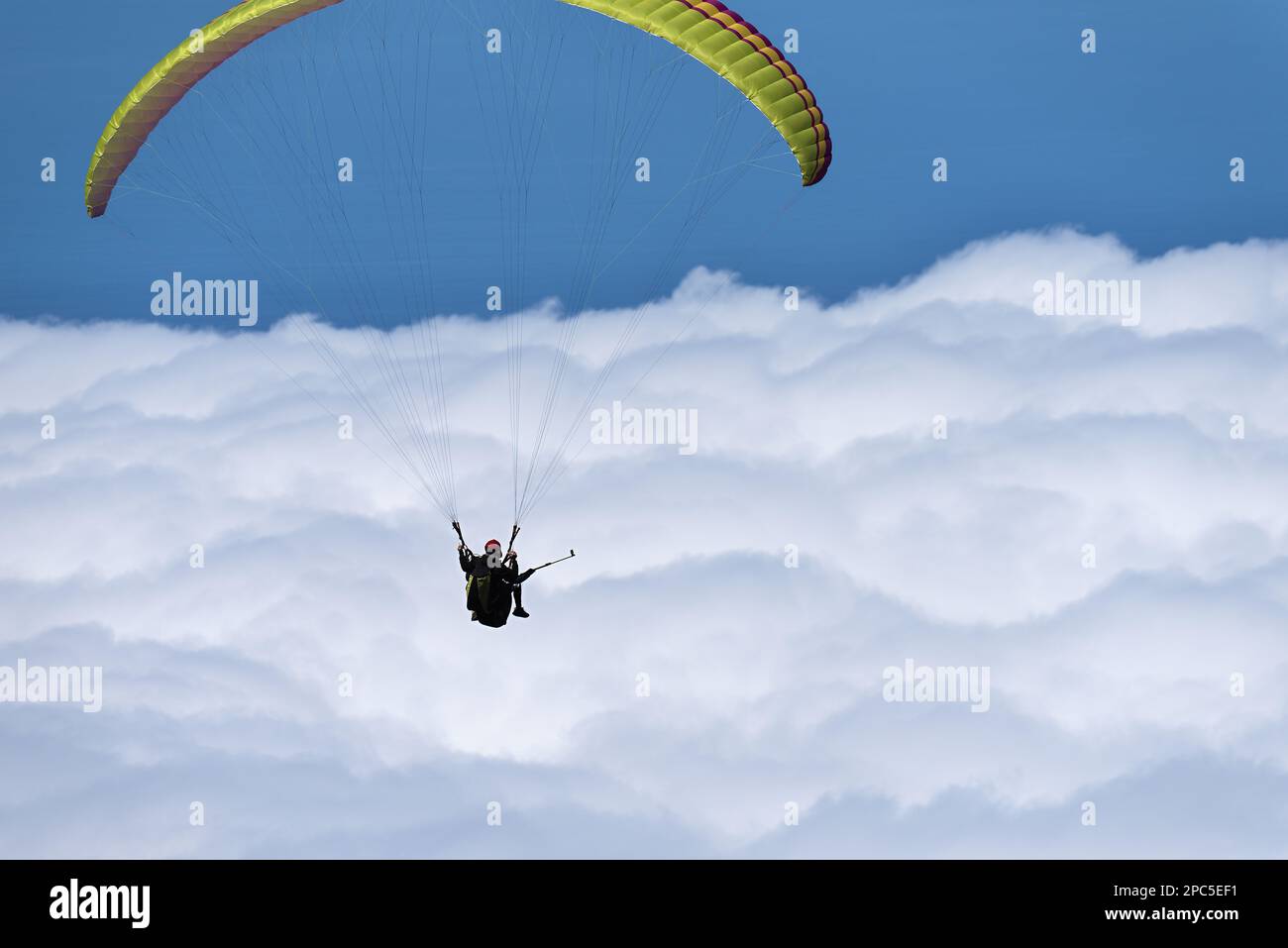 Two people are flying on a paraglider in the sky. Tandem flight above ...