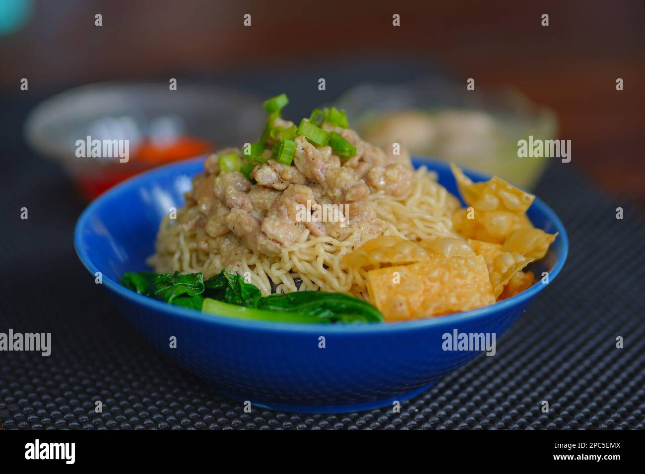 Mie Ayam or Indonesian chicken noodles with broth served in bowl with ...