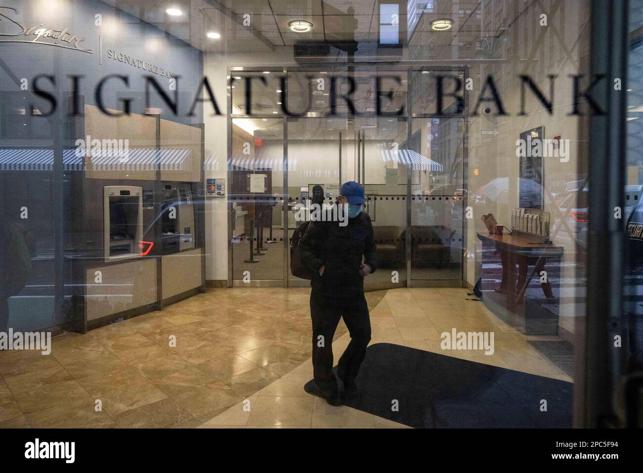 A person leaves one of the Signature Bank branches in New York, Monday ...