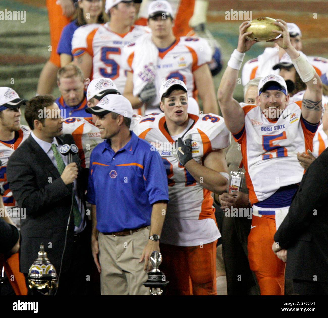 Boise State quarterback Jared Zabransky (5) holds up a golden football ...