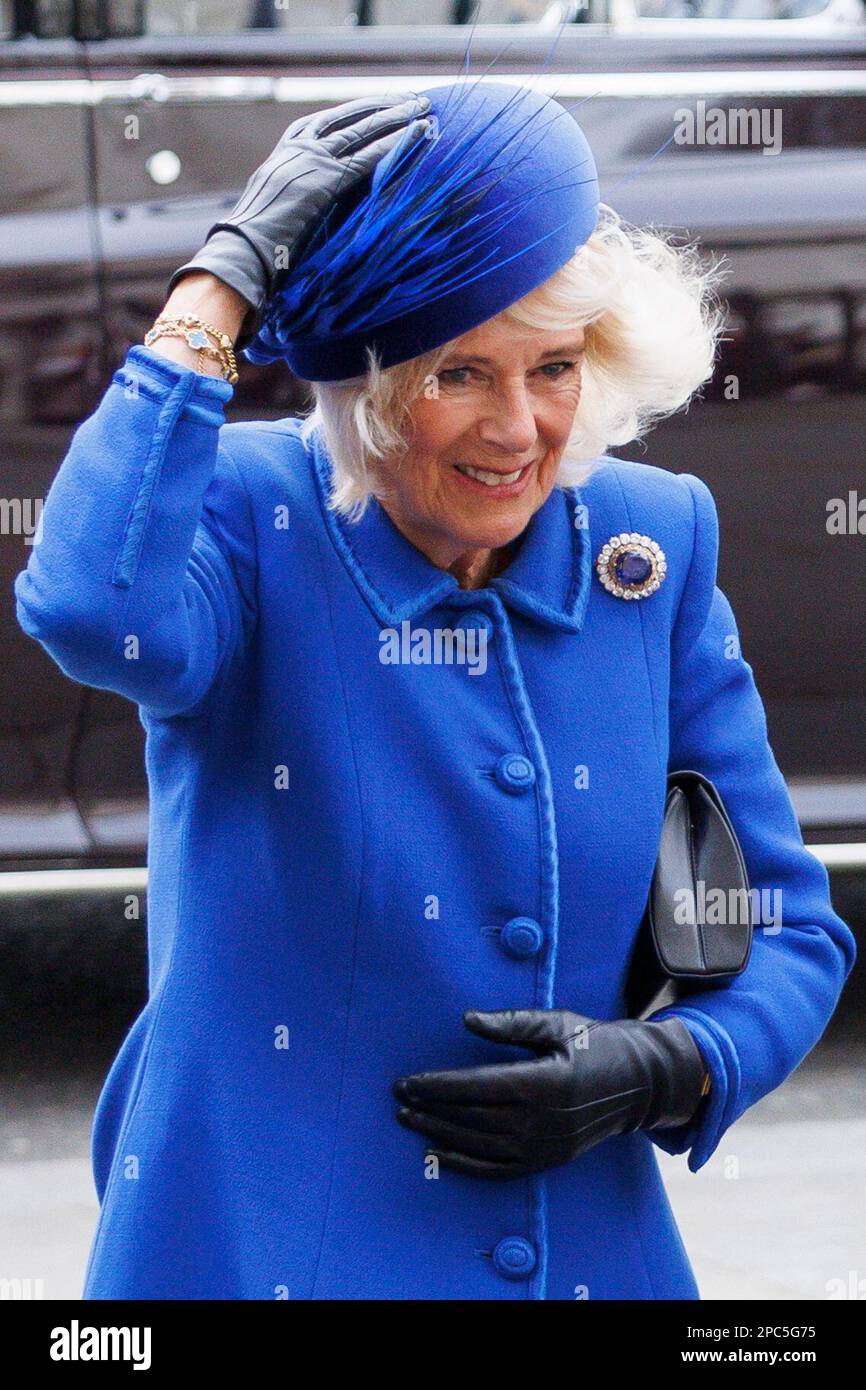 The Queen Consort holds onto her hat as she arrives for the annual ...
