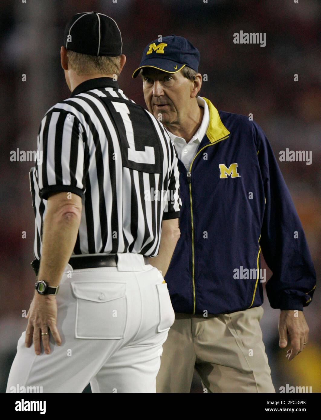 Michigan head coach Lloyd Carr, right, talks with line judge Rick Page ...