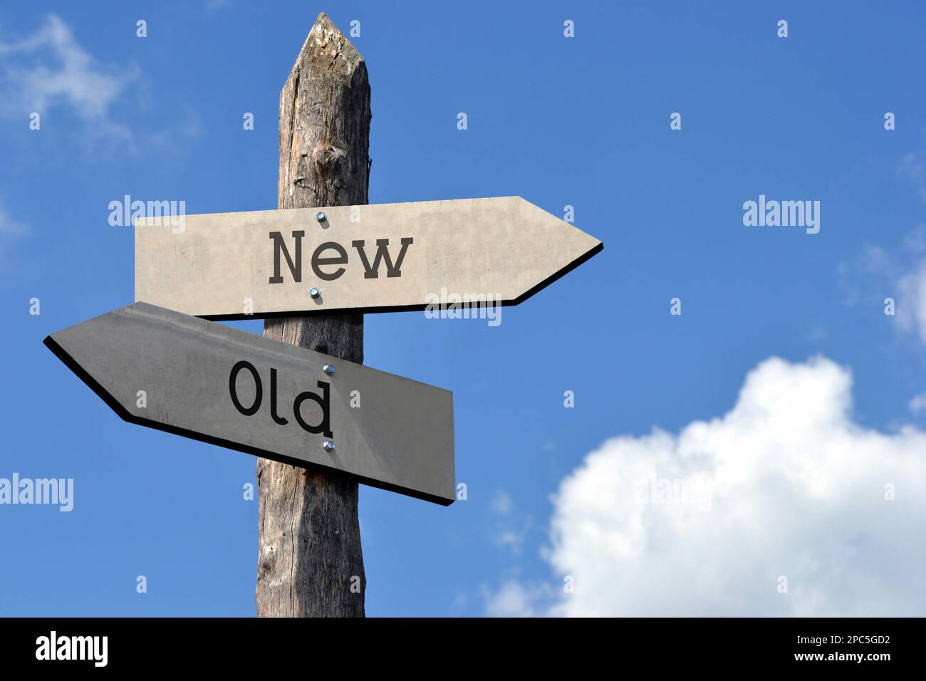 Old or new - wooden signpost with two arrows, sky with clouds Stock ...