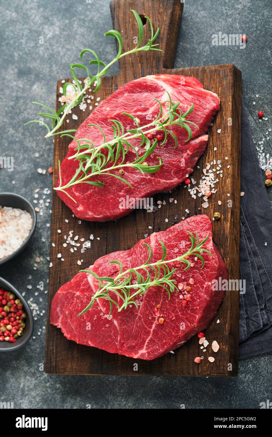 Raw beef steak. Marbled raw fresh Ribeye steak with rosemary, salt and ...