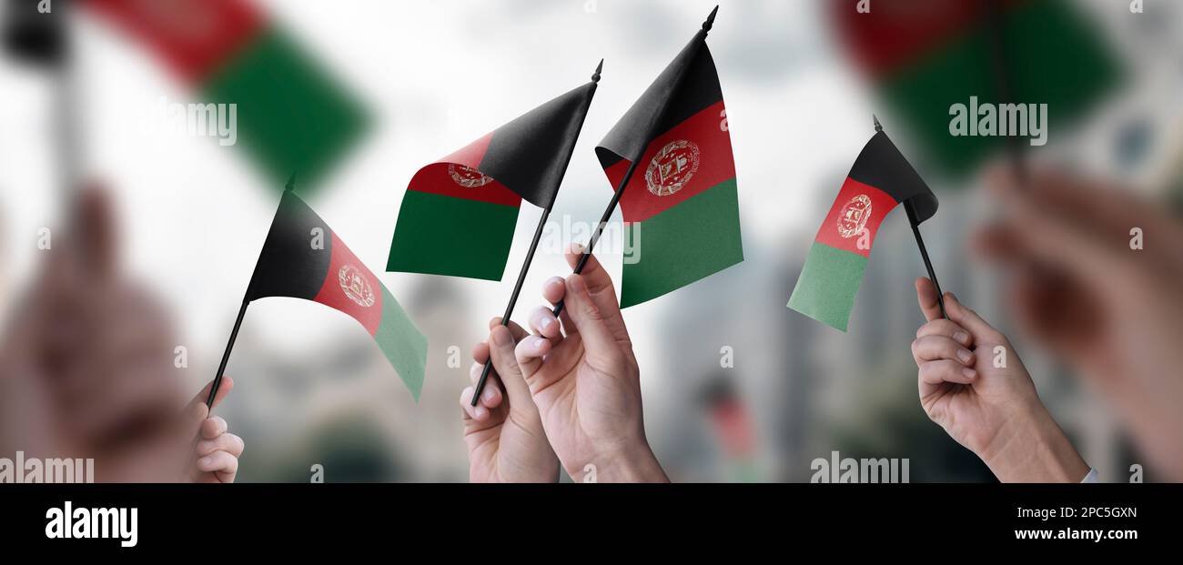 A group of people holding small flags of the Afghanistan in their hands ...