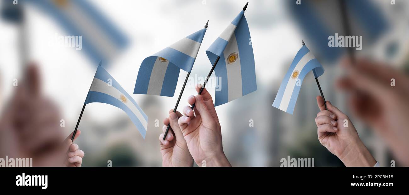 A group of people holding small flags of the Argentina in their hands ...