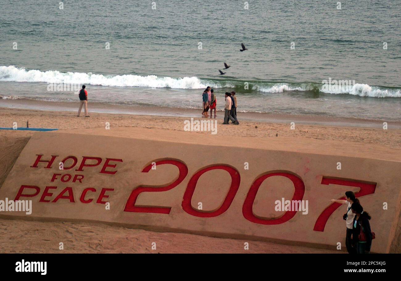 Tourists look at a sand art created by Indian sand artist Sudarsan ...