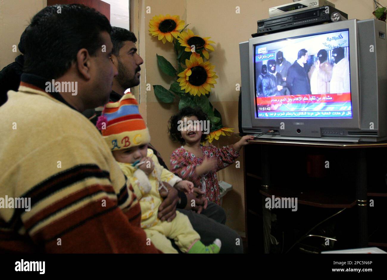 An Iraqi family watches television in their home in Basra, 550 ...