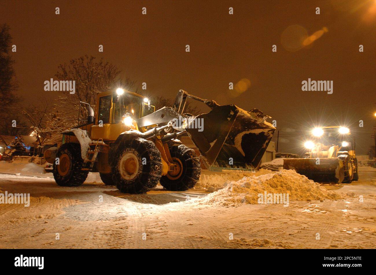 Front end loaders plow snow from a side street in Denver Friday, Dec ...