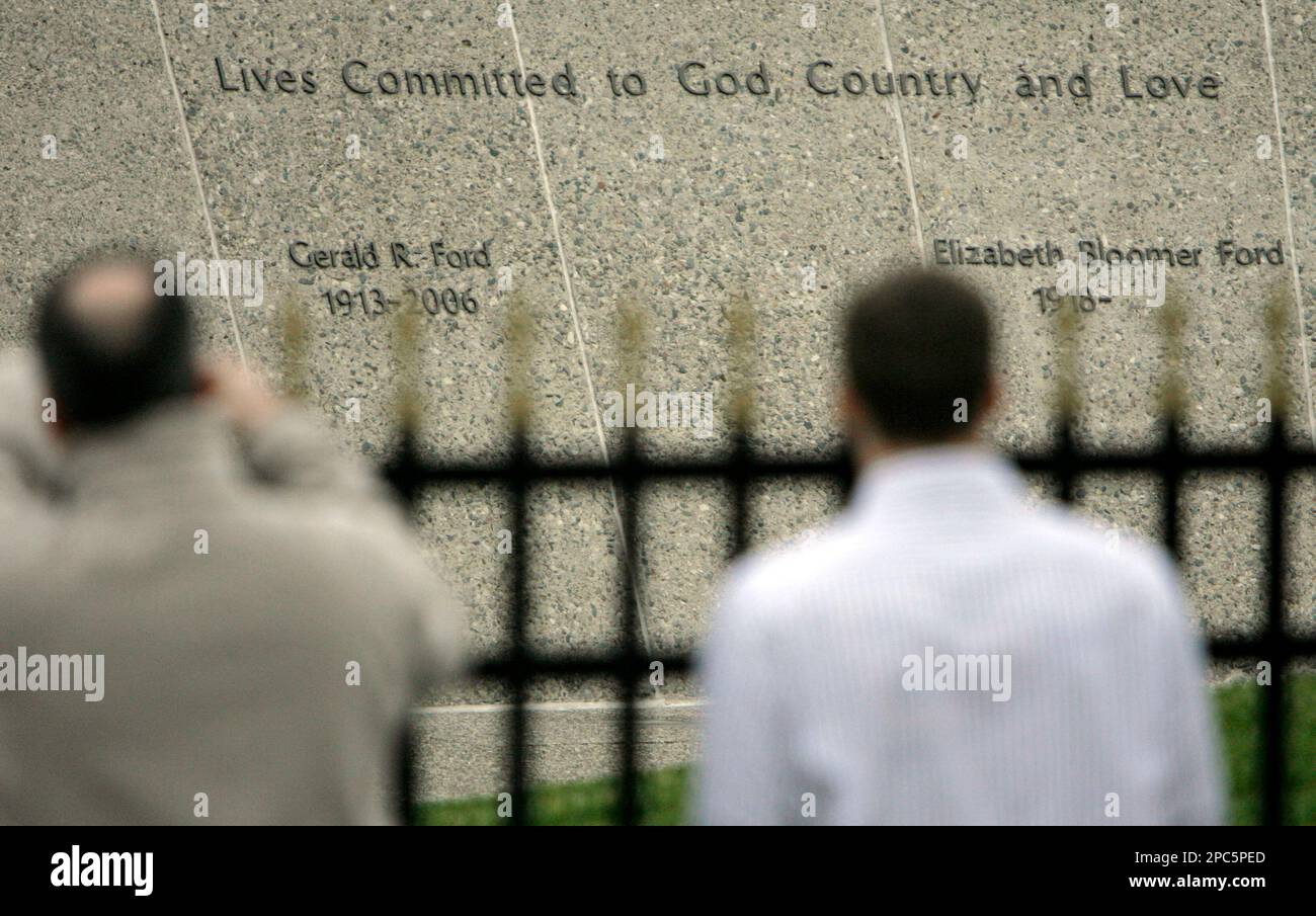 Passers-by view the newly installed type on the tomb Friday, Dec. 29 ...