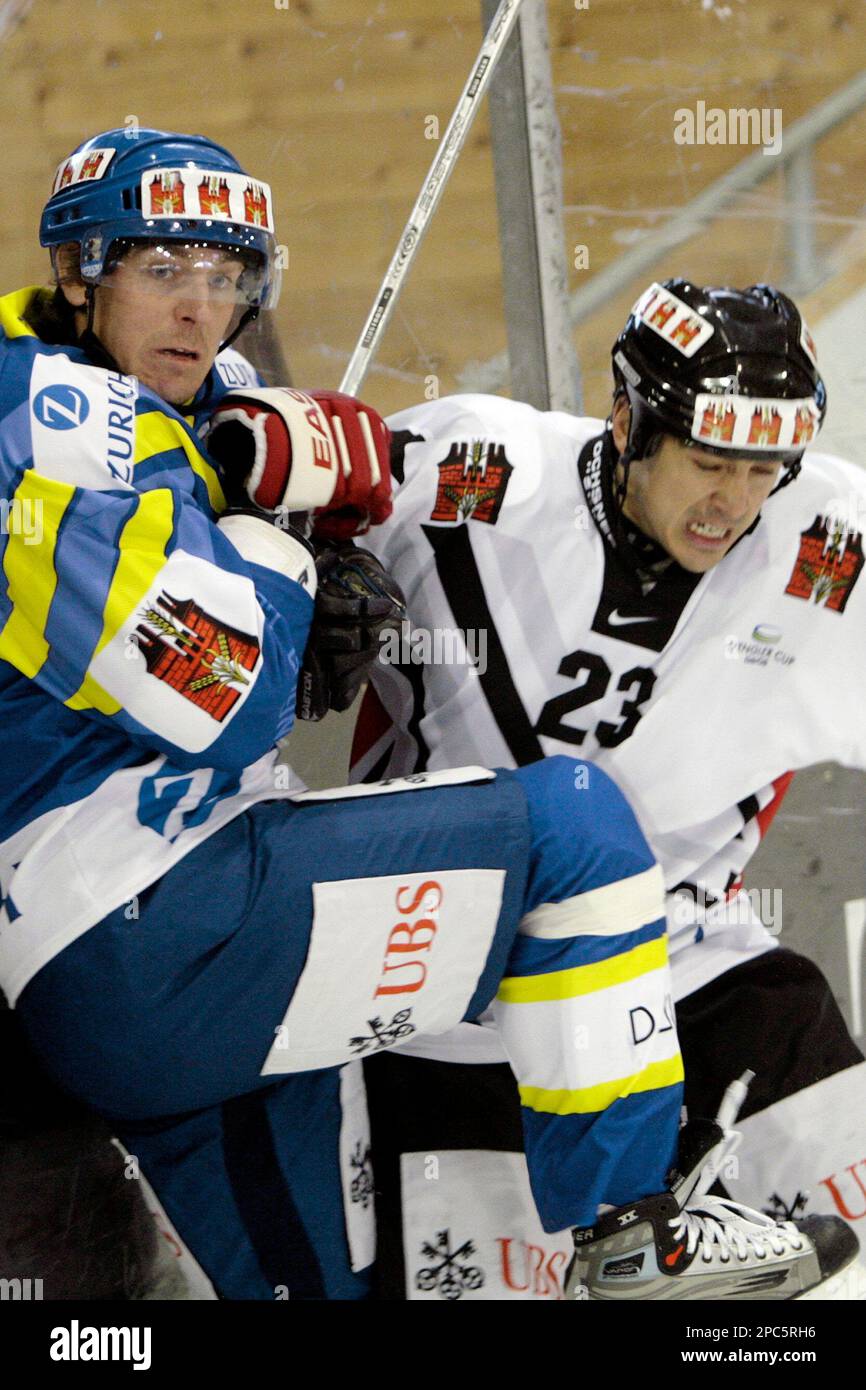Russian player of Khimik Alexander Titov, left, fights with Team Canada ...