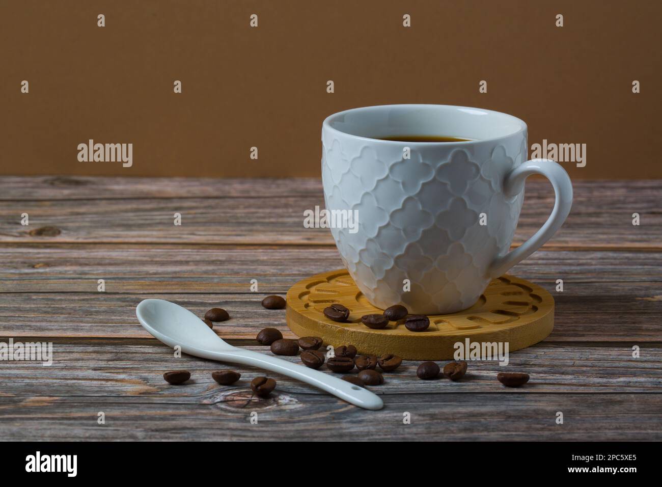 White espresso cup and coffee beans wooden table background with copy ...