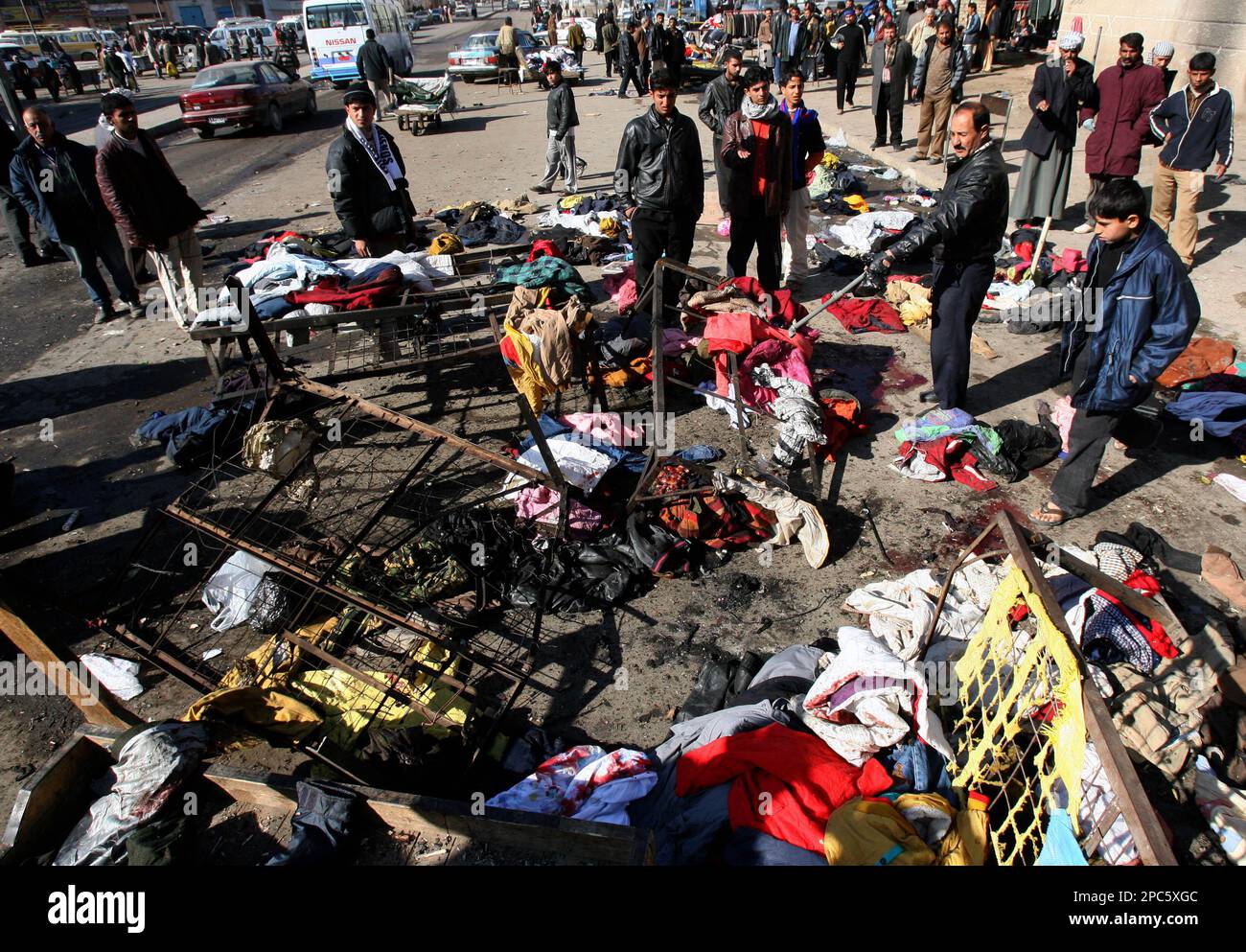 Iraqis stand amid scattered clothes and destroyed vendor booths after a ...