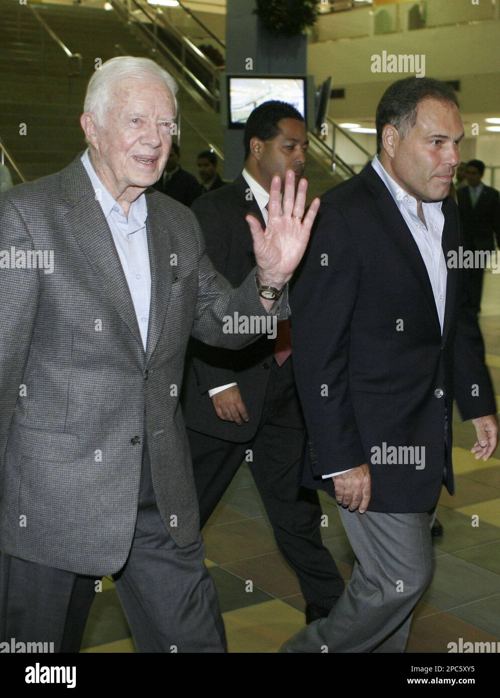 Former President Jimmy Carter, left, salks with Samuel Lewis Navarro ...