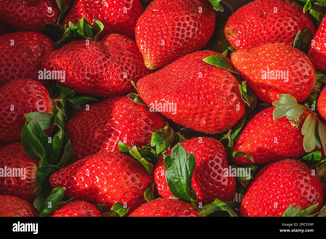 Fresh ripe big red strawberries fruit with green leaves in a street ...