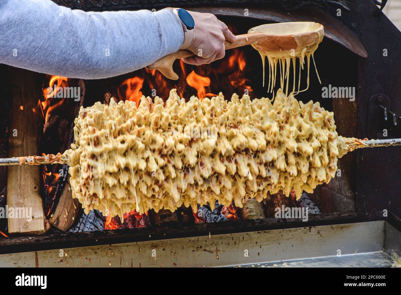 Preparing Lithuanian tree cake, šakotis or baumkuchenas, Polish sękacz ...