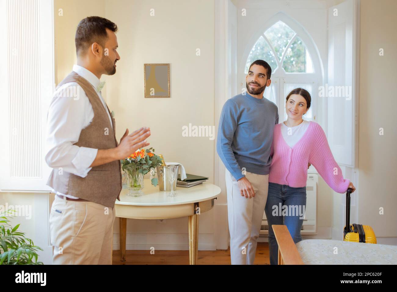 Happy Tourists Couple Checking In At The Hotel Reception Indoors Stock ...
