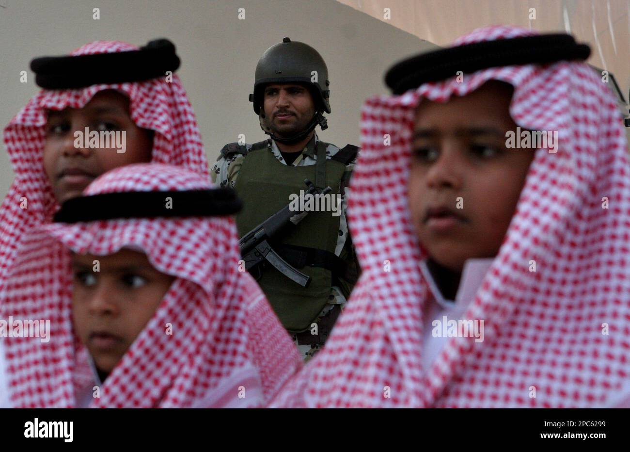 Saudi boys wear the tradition clothing as a commando seen behind ...